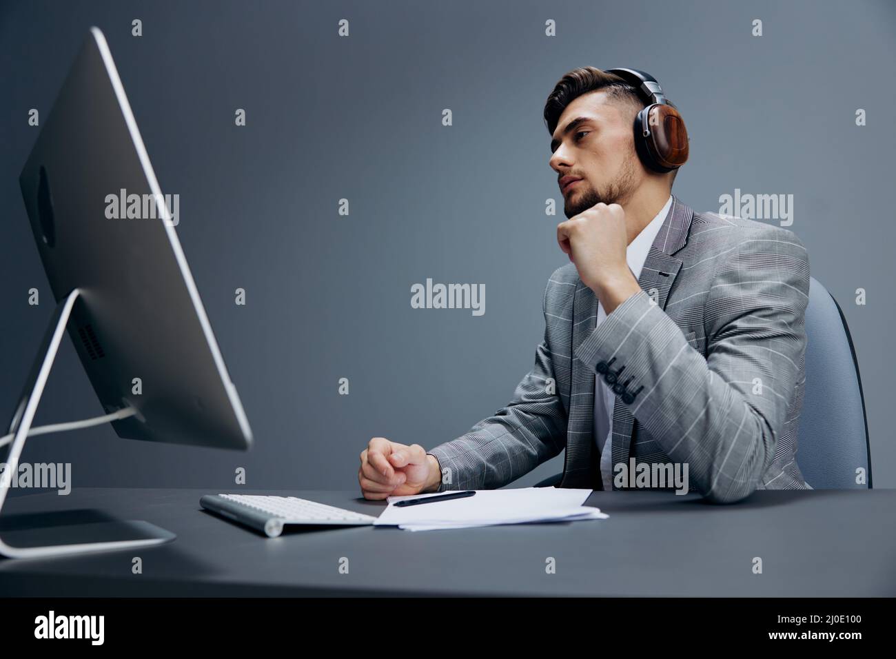manager working at the computer in headphones in the office Gray ...