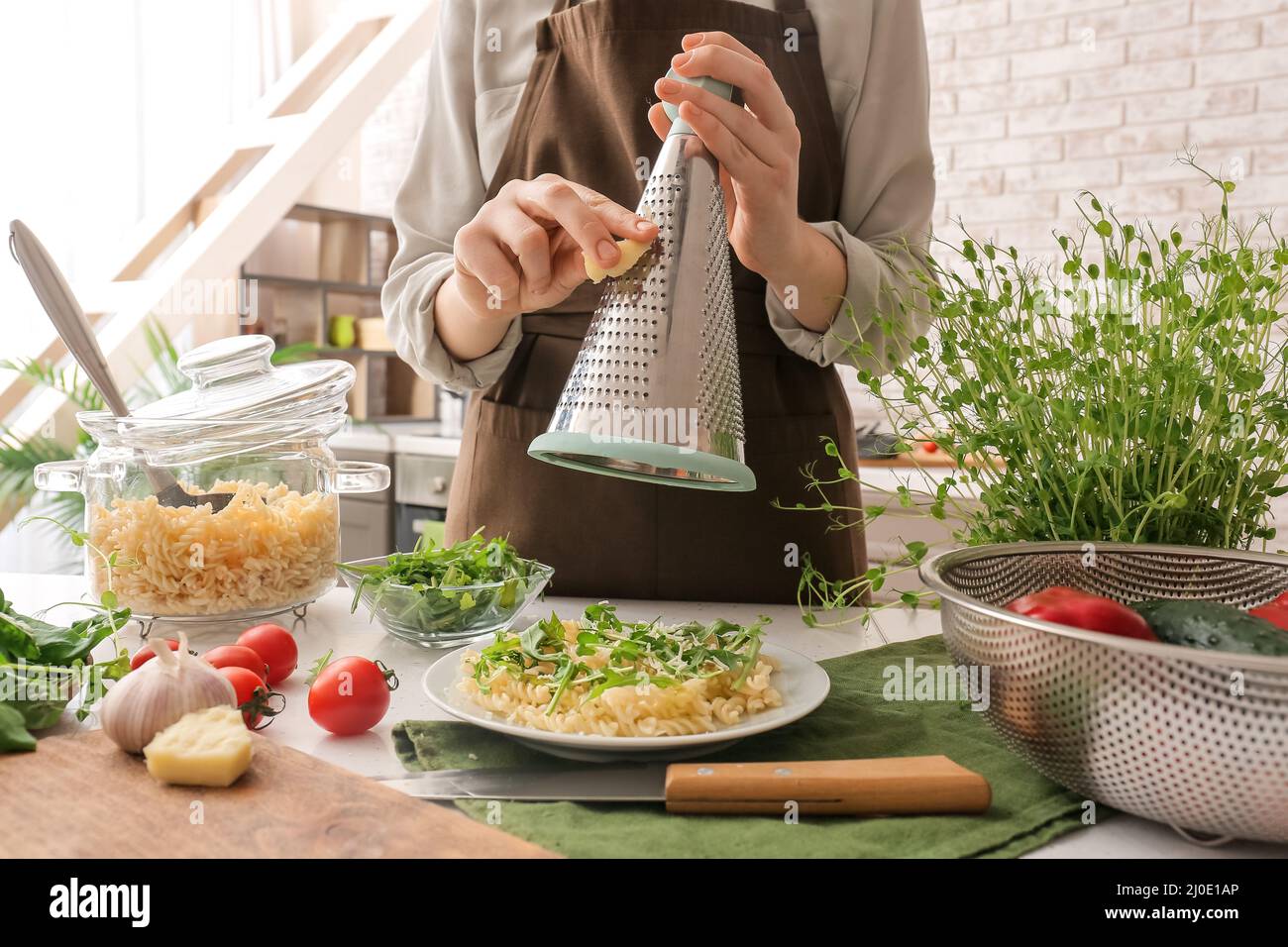 Woman grating cheese onto hi-res stock photography and images - Alamy