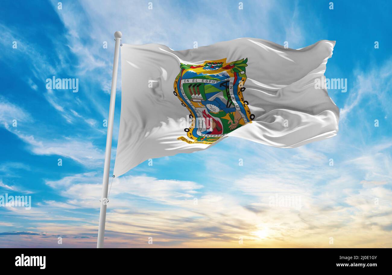 flag of Puebla , Mexico at cloudy sky background on sunset, panoramic ...