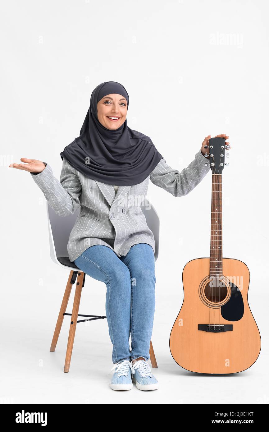 Muslim music teacher with guitar on light background Stock Photo - Alamy