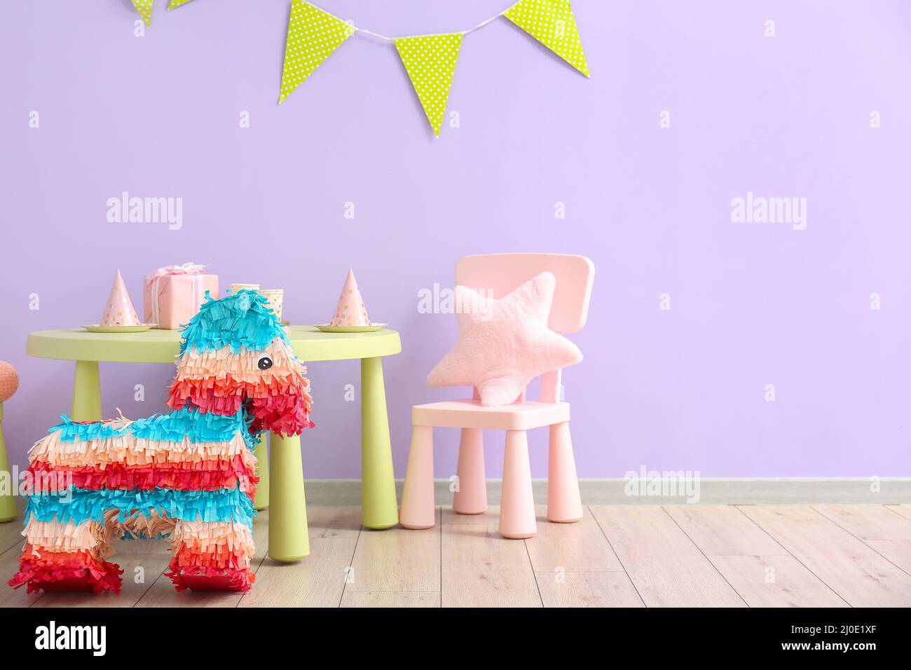 Interior of children's room with table, chair and Mexican pinata ...