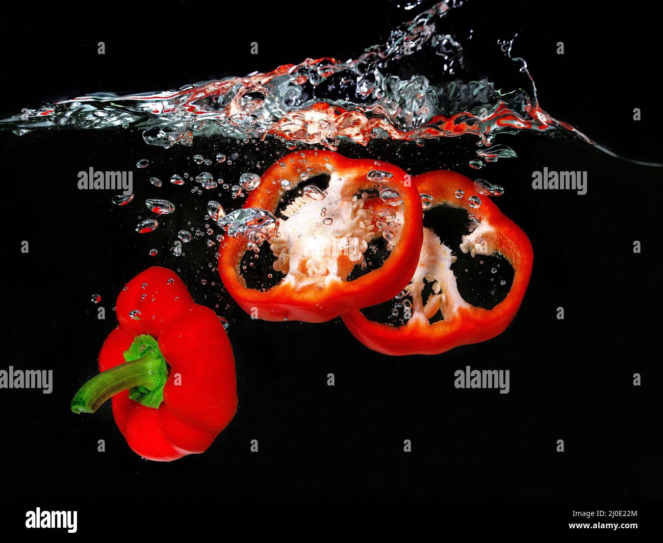 red pepper falling in the boiling water on dark background. Underwater ...