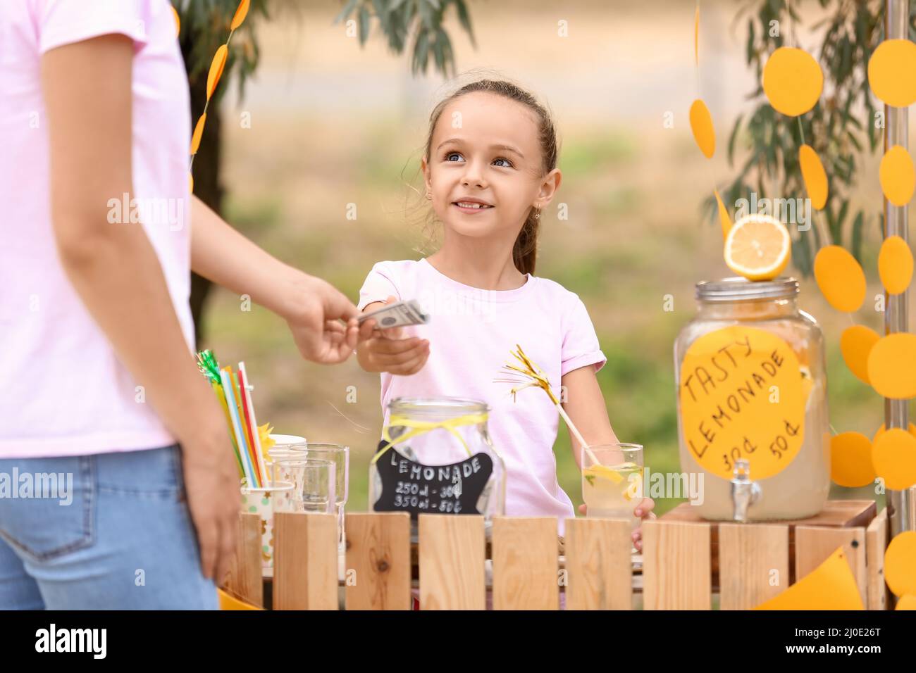 Cute girl selling lemonade in park Stock Photo - Alamy