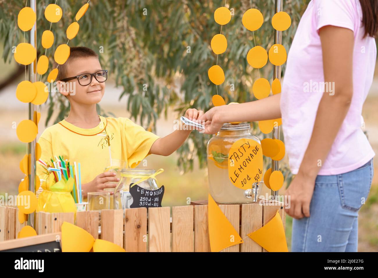Cute boy selling lemonade in park Stock Photo - Alamy