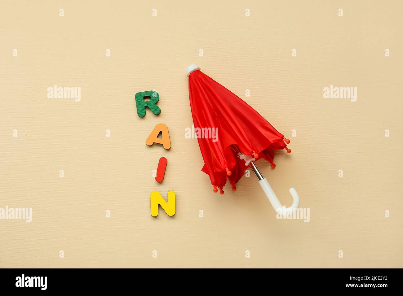 Red umbrella and word RAIN made of colorful letters on color background ...