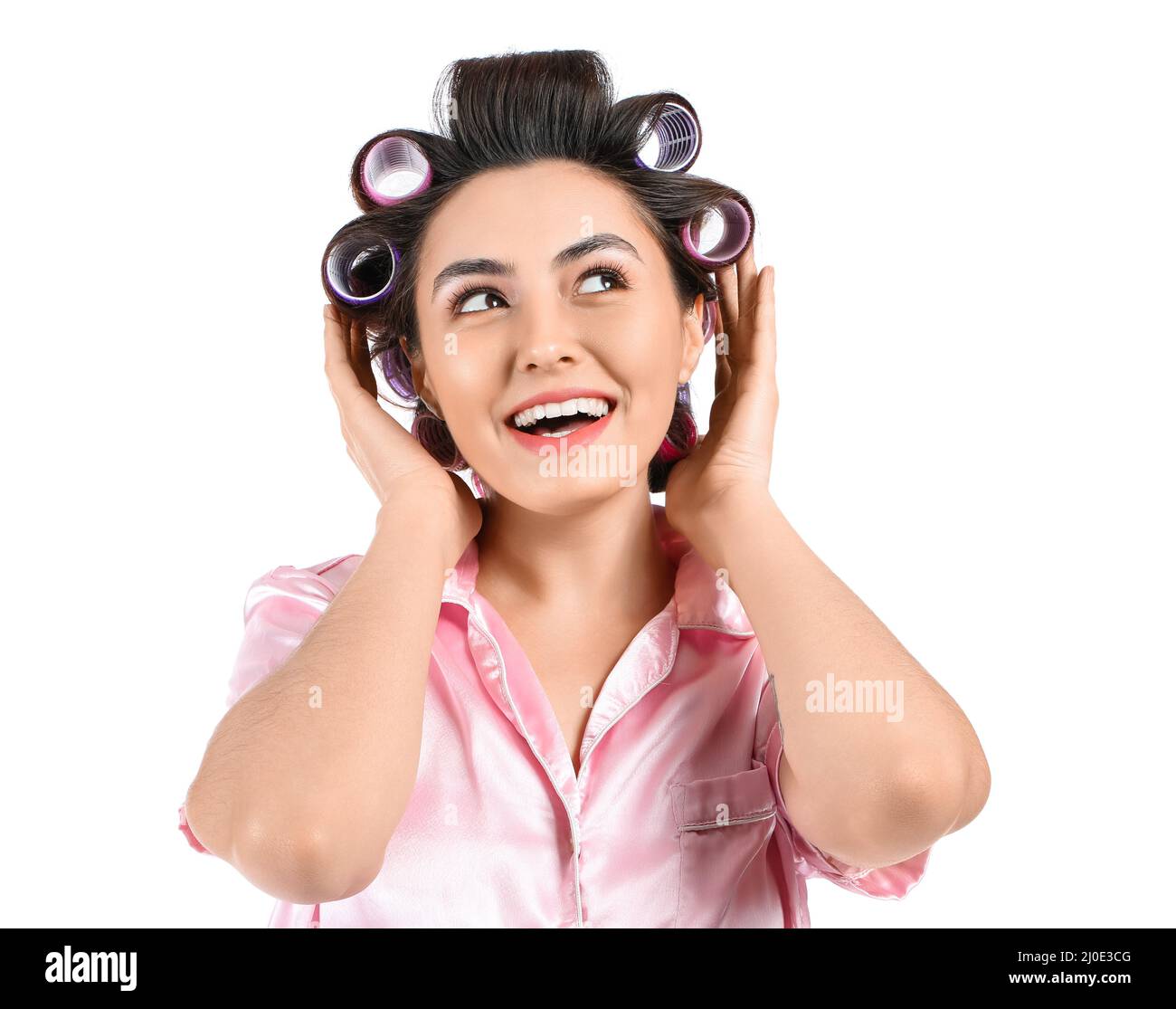 Happy young woman in pajamas and hair curlers on white background Stock ...