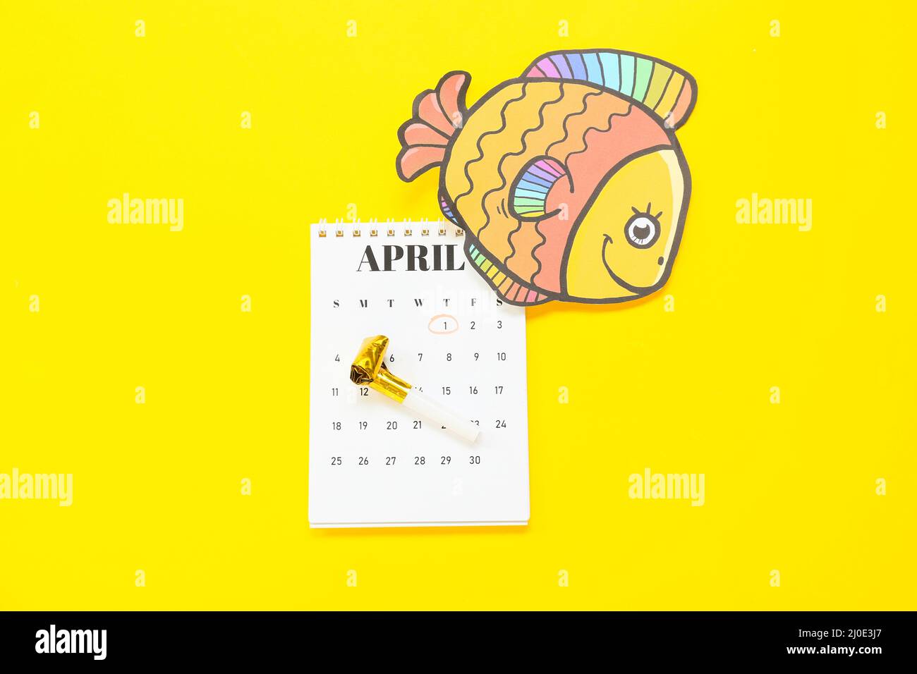 Calendar with marked date of April Fool's Day, party whistle and paper ...