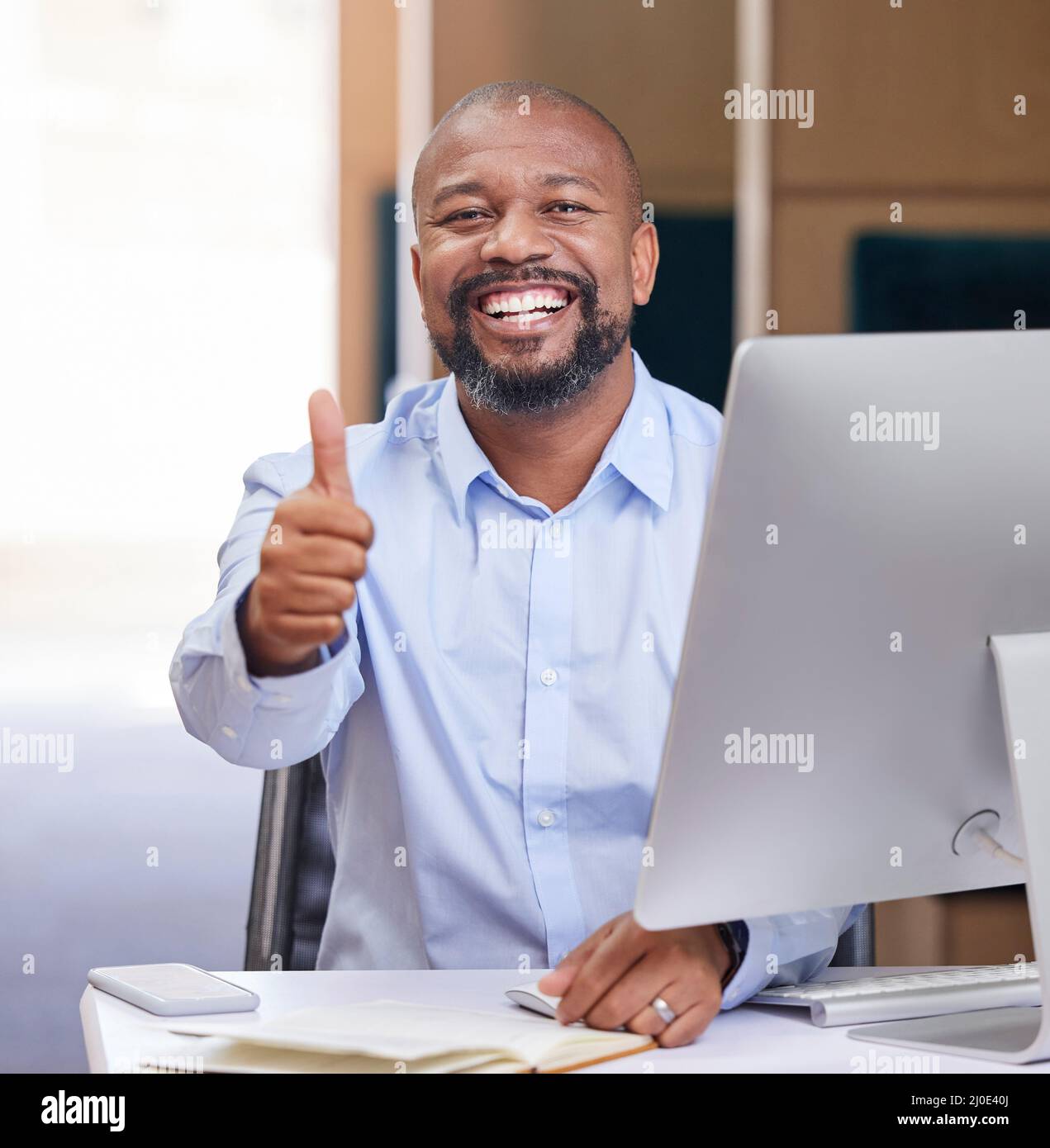 Thumbs up for a good work day. Shot of a young businessman showing a ...