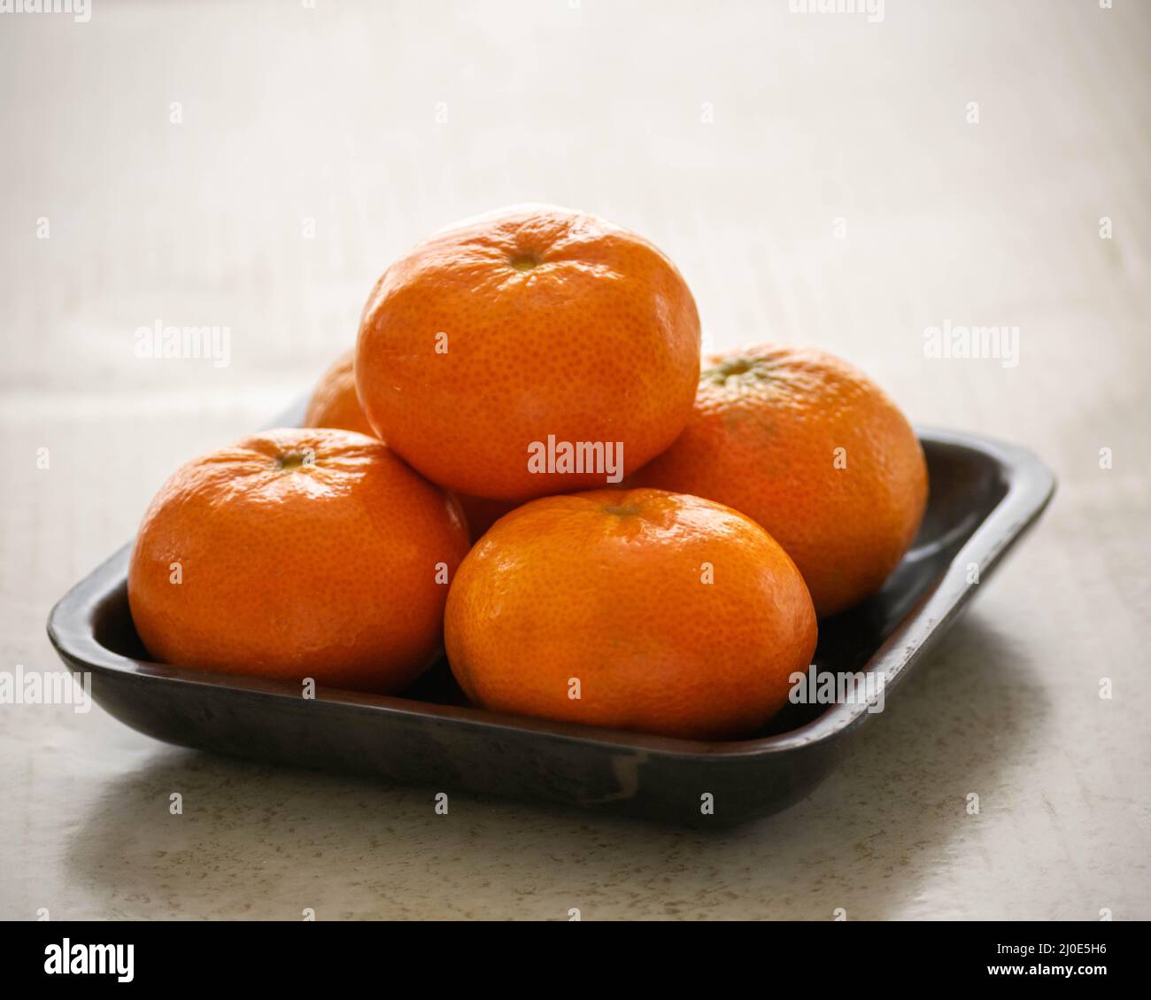 Mandarin oranges on black tray hi-res stock photography and images - Alamy