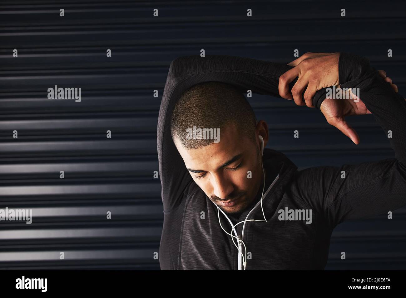 Warming up is his meditation. Shot of an athletic young man warming up ...