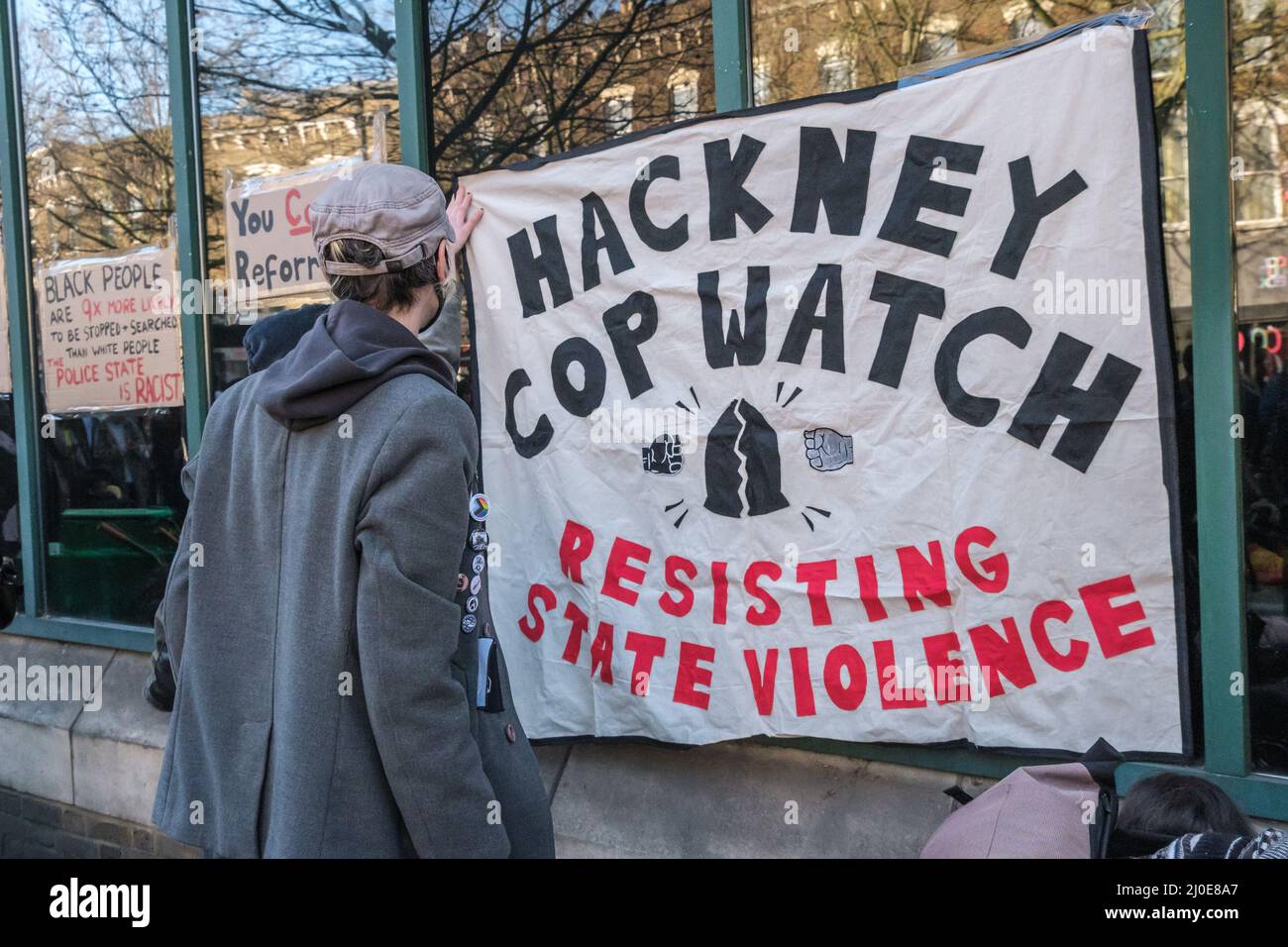 London, UK. 18th Mar 2022. The Hackney Cop Watch banner is taped to the ...