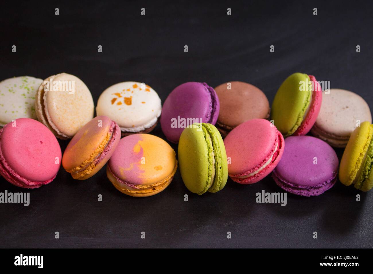 Assorted colorful macaroons on a dark background Stock Photo - Alamy