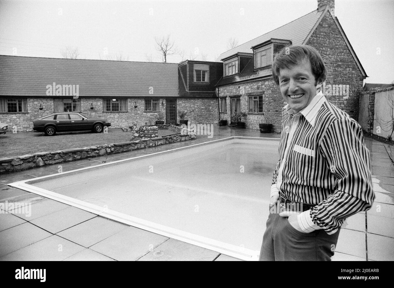 Magician Paul Daniels beside his swimming pool and house in ...