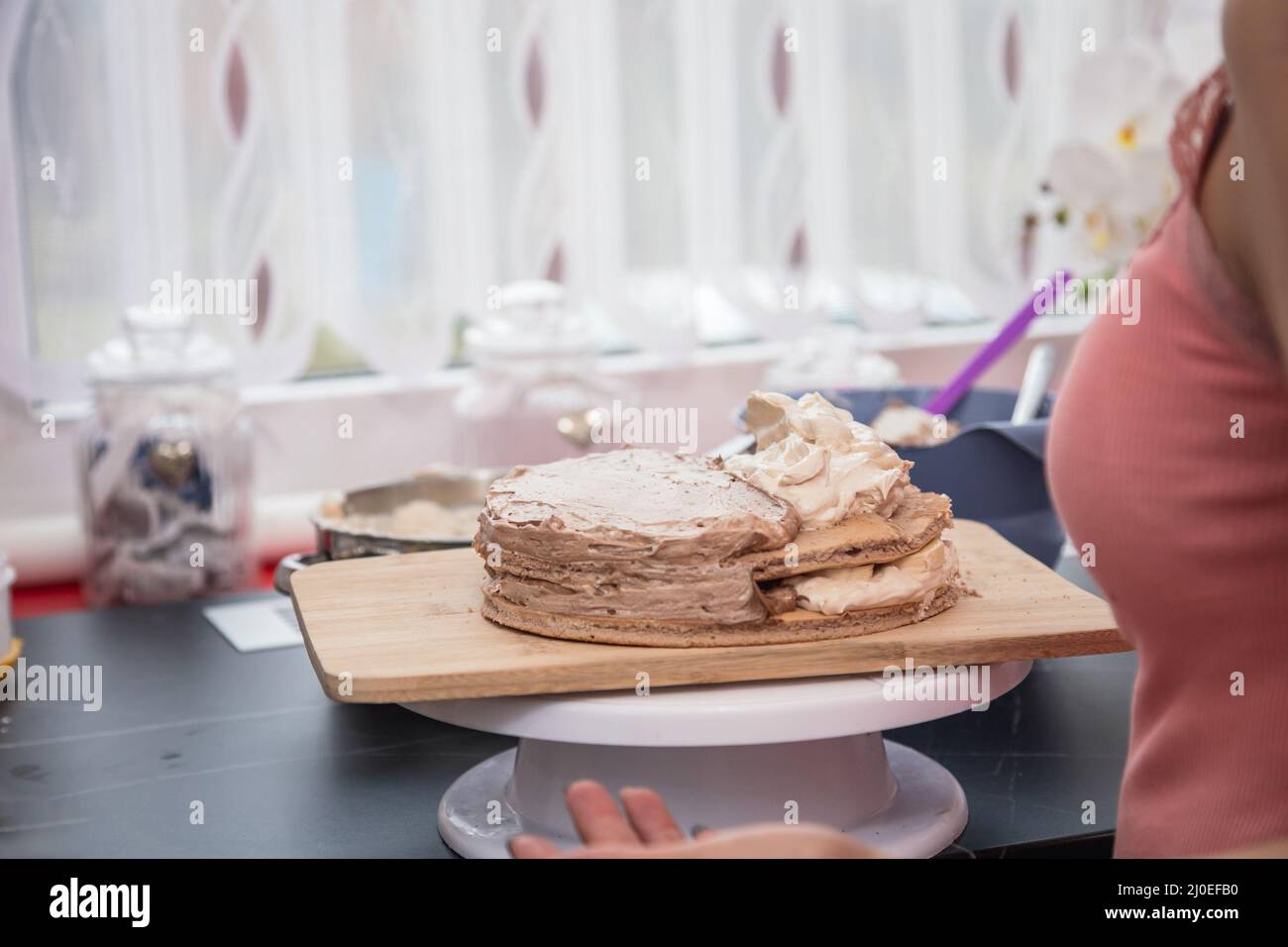 Female preparing a multi-layered cake with cream Stock Photo - Alamy