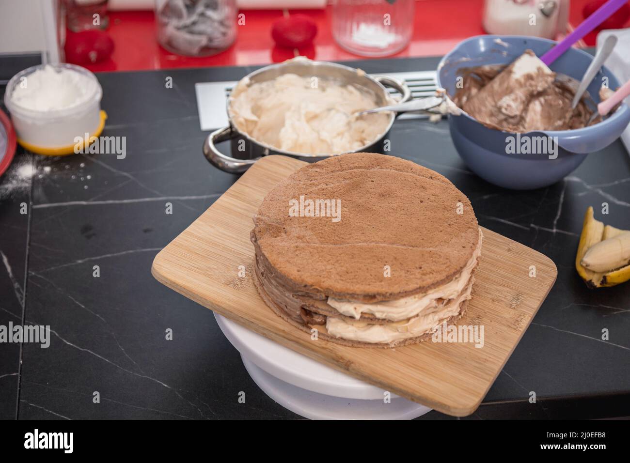 Female preparing a multi-layered cake with cream Stock Photo - Alamy
