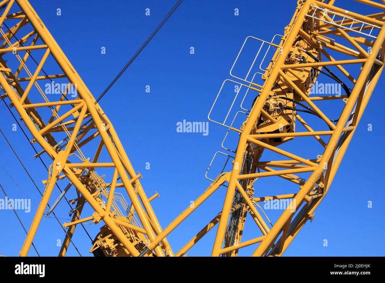 Two yellow crane arms Stock Photo - Alamy