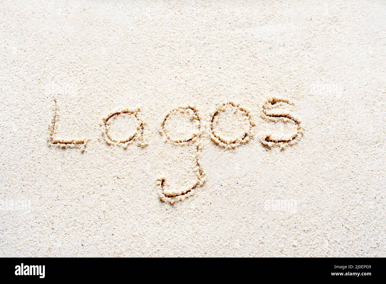 Handwriting words "Lagos" on sand of beach Stock Photo - Alamy