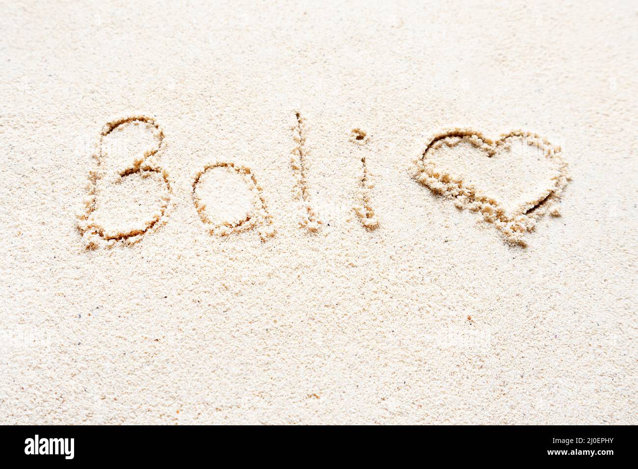 Handwriting words "Bali" on sand of beach Stock Photo - Alamy