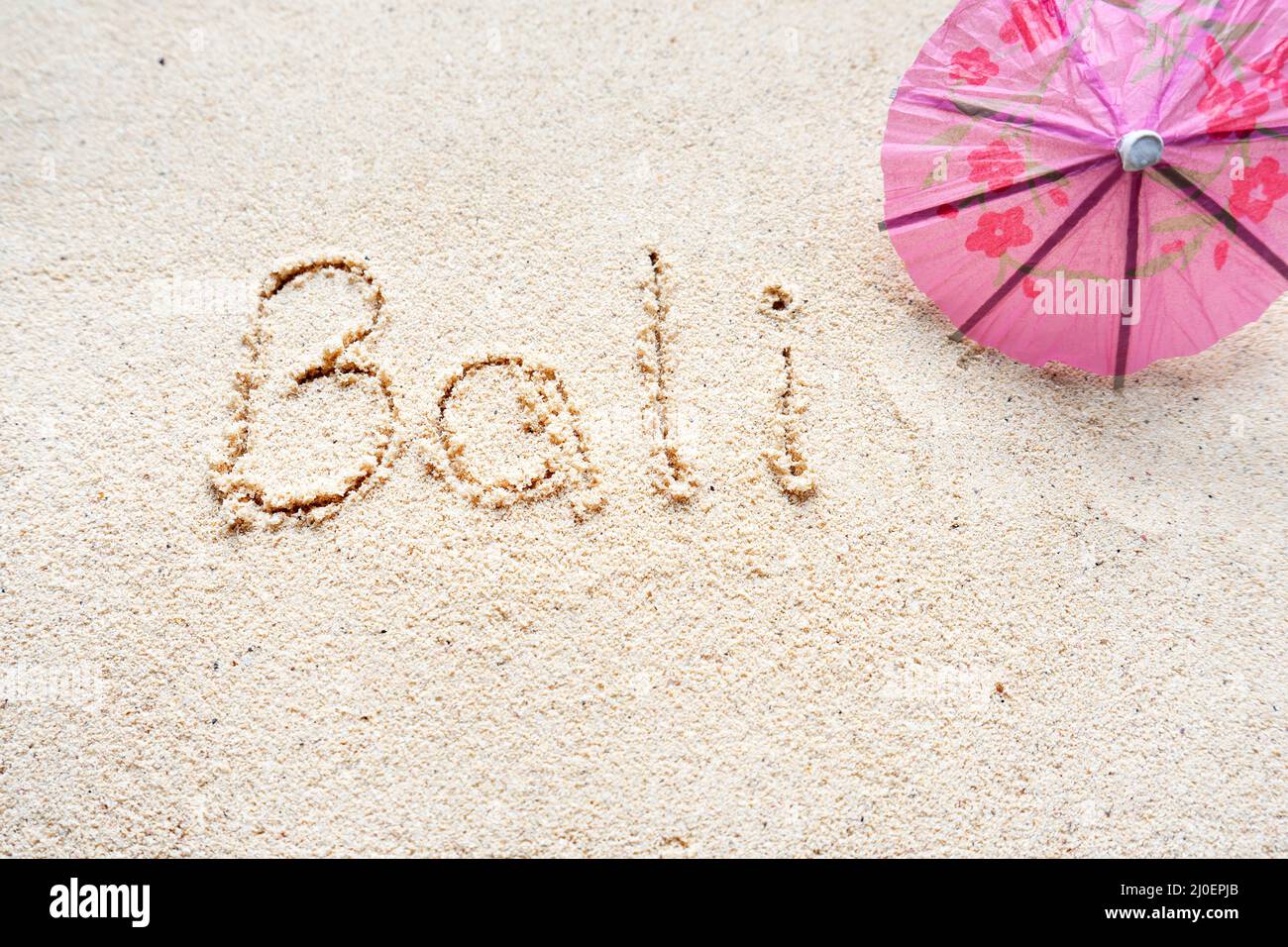 Handwriting words "Bali" on sand of beach Stock Photo - Alamy