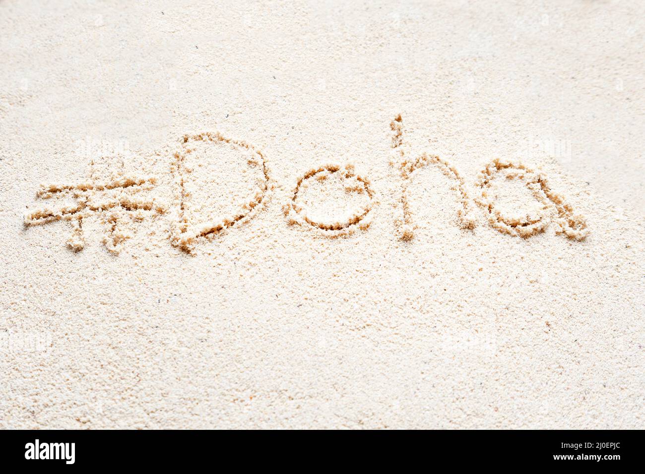 Handwriting words "Doha" on sand of beach Stock Photo - Alamy