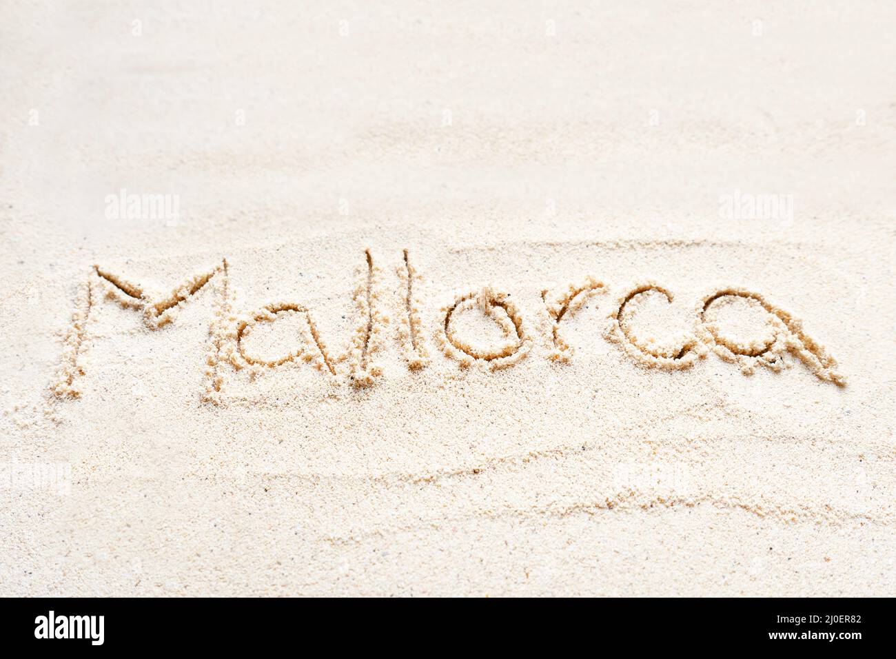Handwriting words "Mallorca" on sand of beach Stock Photo - Alamy