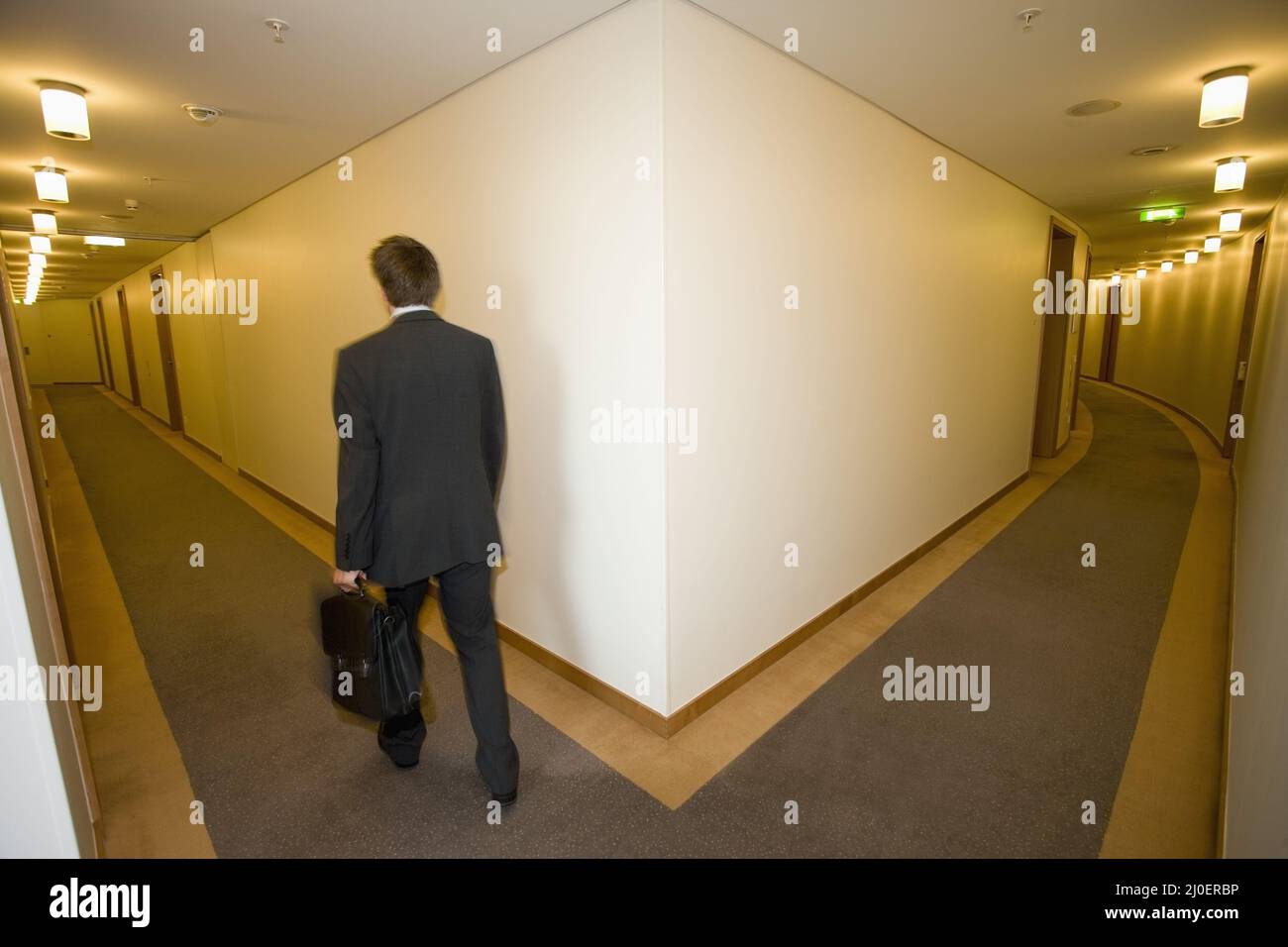 A businessman walking down a corridor Stock Photo - Alamy