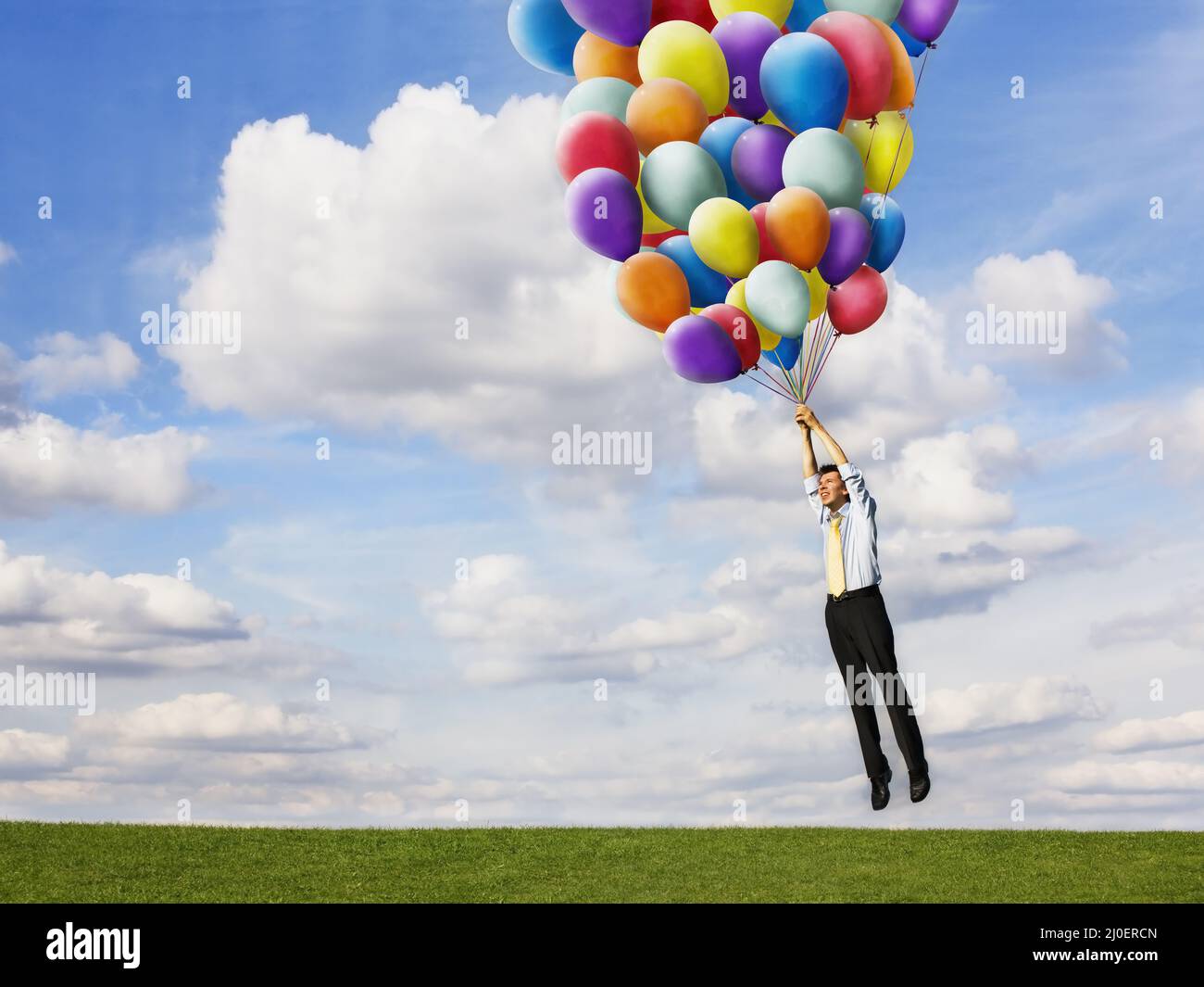 Businessman taking off holding Helium Balloons Stock Photo - Alamy