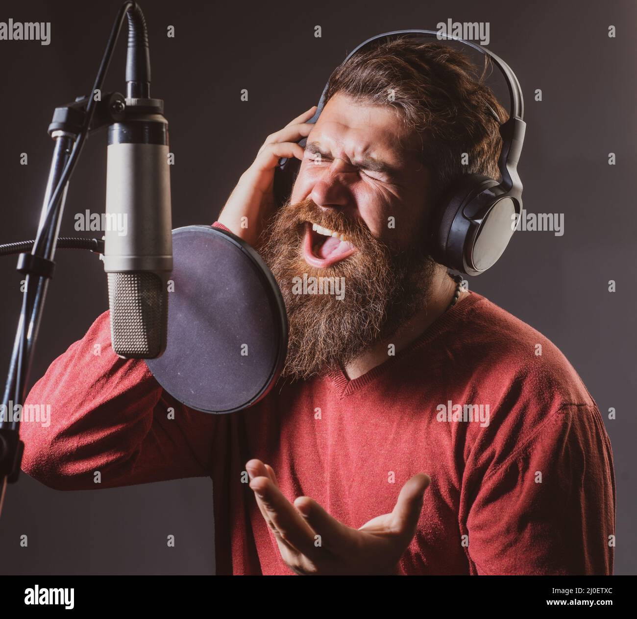 Excited man with microphone singing song. Musician in music hall. Funny ...