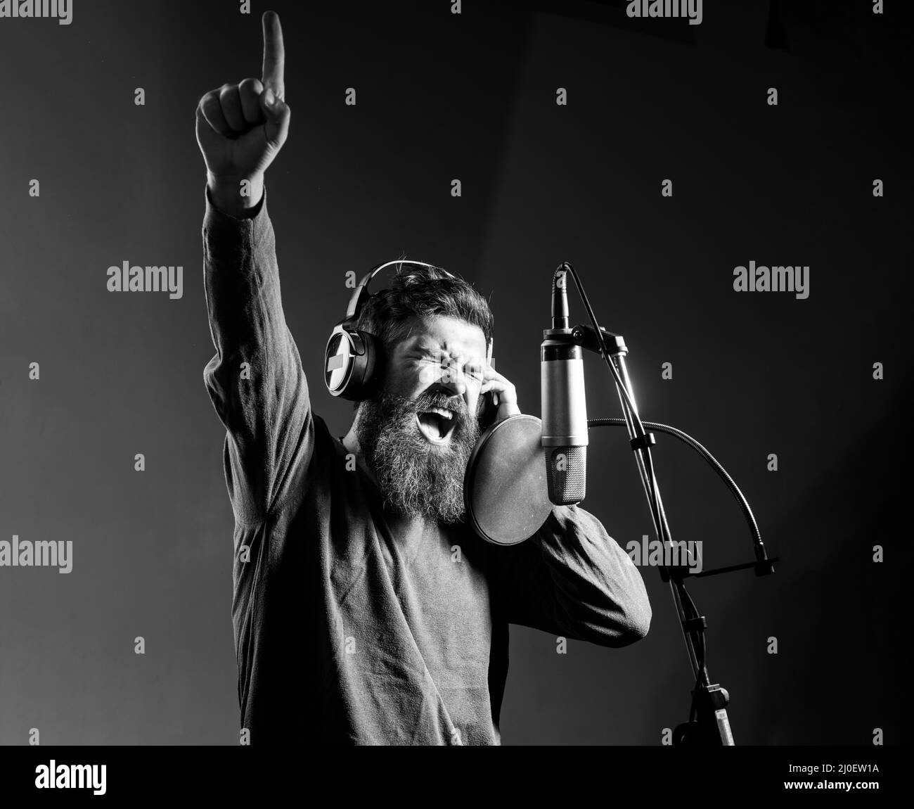 Singer with expression face wearing headphones is performing a song ...