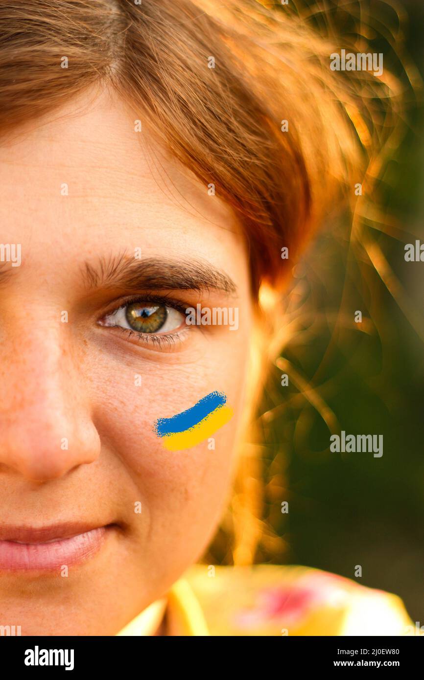 Ukrainian woman. Ukrainian flag on the cheeks. Portrait of a young ...