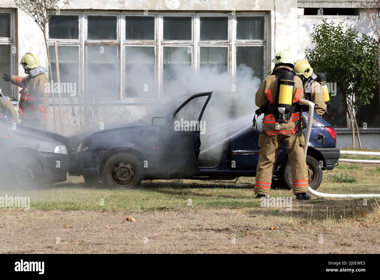Firefighters extinguishing burning car hi-res stock photography and ...