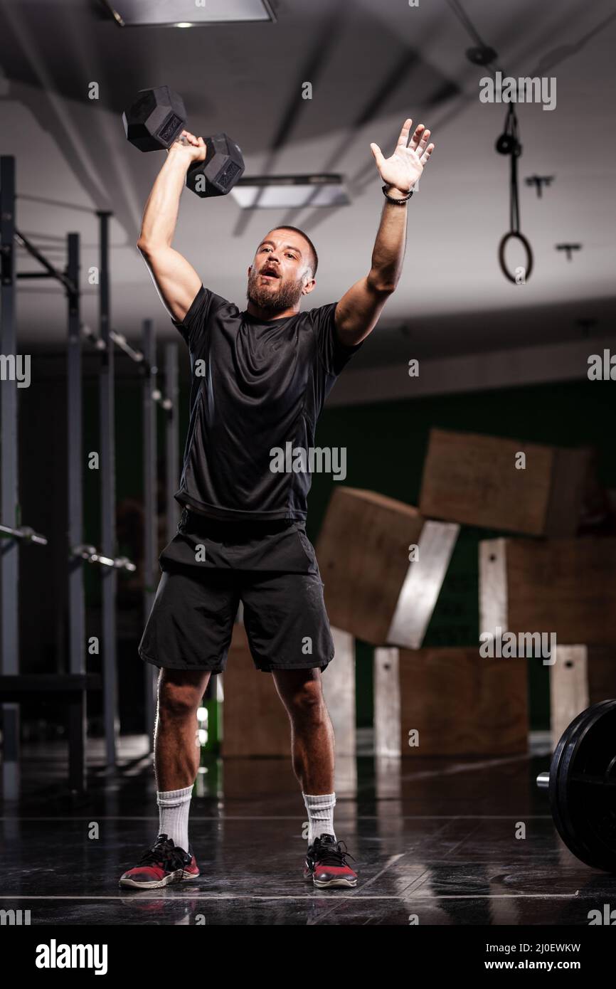 Muscular athlete lifting very heavy weights. Man working out indoors ...