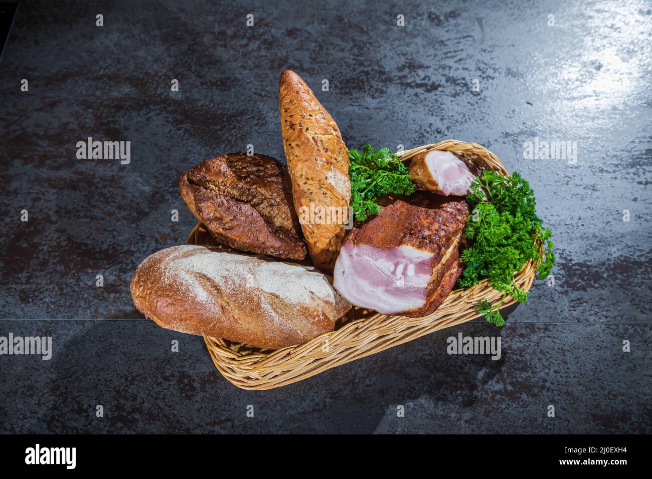 Bread and smoked meat in a braided basket on the table Stock Photo - Alamy