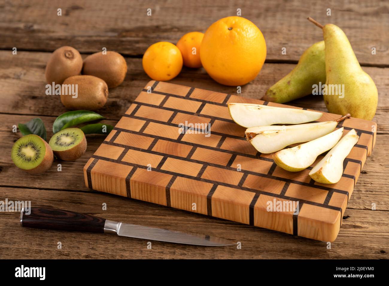 Fruit with knife on wooden cutting board Stock Photo - Alamy