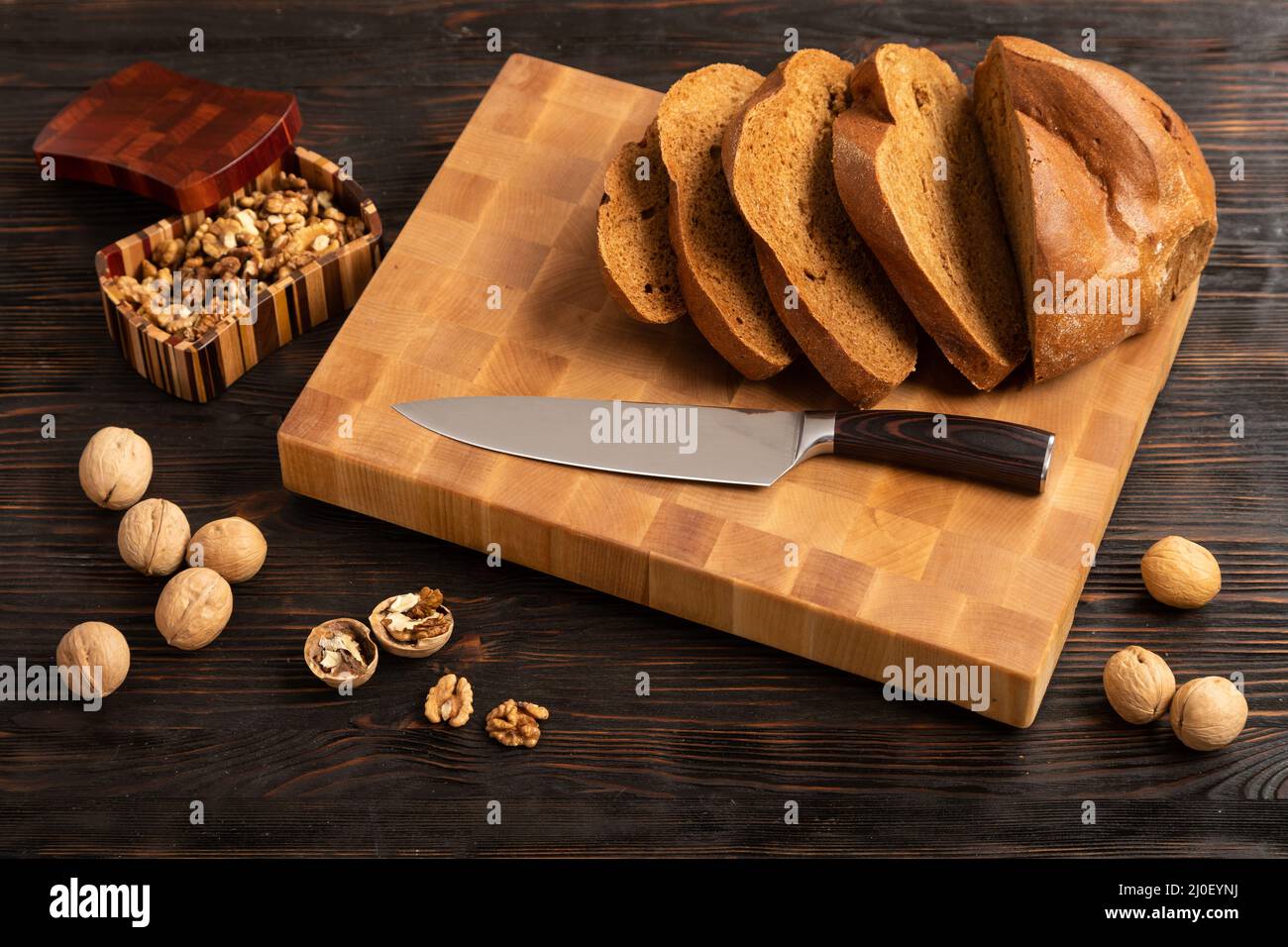 A loaf of bread sliced into slices with a knife Stock Photo - Alamy