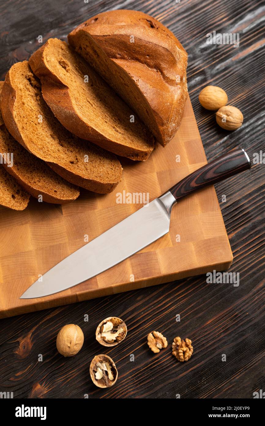 A loaf of bread sliced into slices with a knife Stock Photo - Alamy