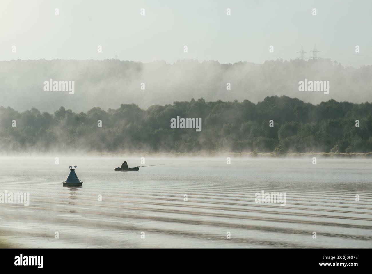 Fisherman fishing on a boat. Early morning spring landscape with river ...