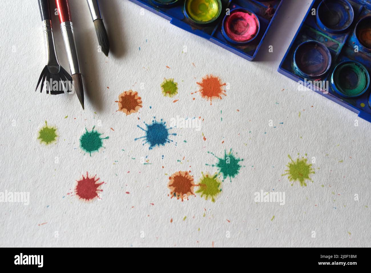 Paintbrushes with the color palettes and the color stains on the rough ...