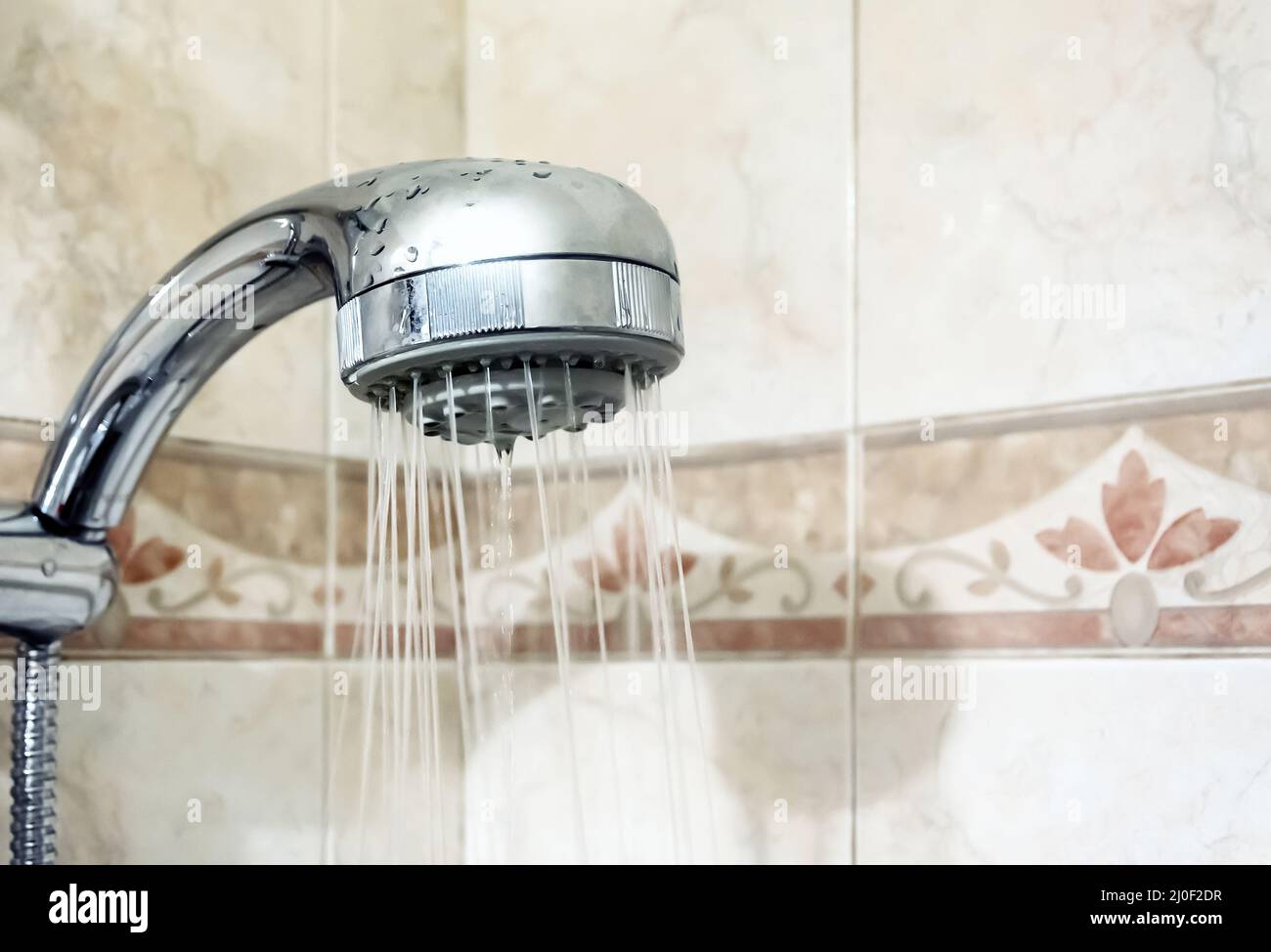 Interior of a shower with water flowing from the shower head. Droplets ...