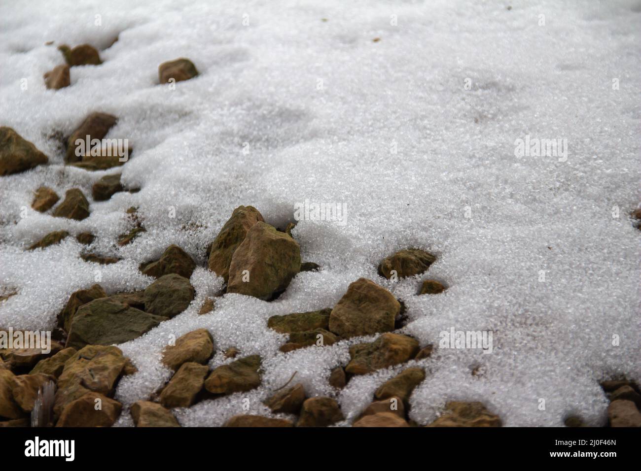 Abstract texture background of white snow covering tan color crushed ...