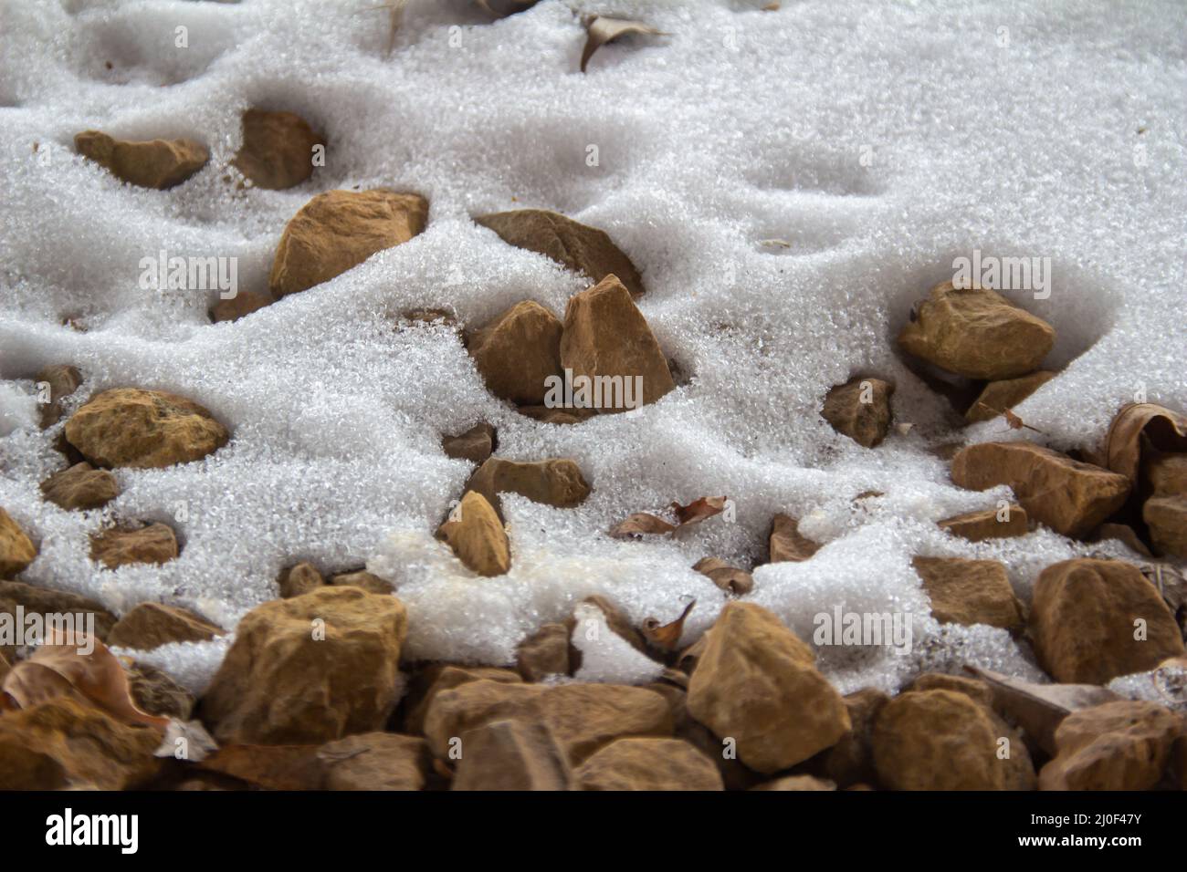 Abstract texture background of white snow covering tan color crushed ...