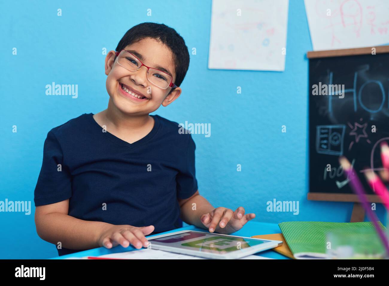 Kindergarten here I come. Portrait of an adorable little boy using a ...