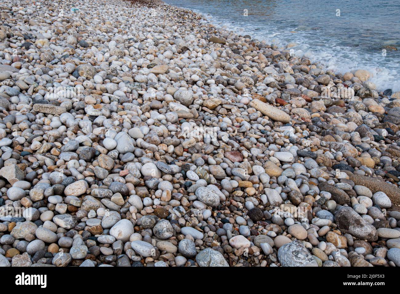 Beautiful and colourful sea pebbles on the beach Stock Photo - Alamy