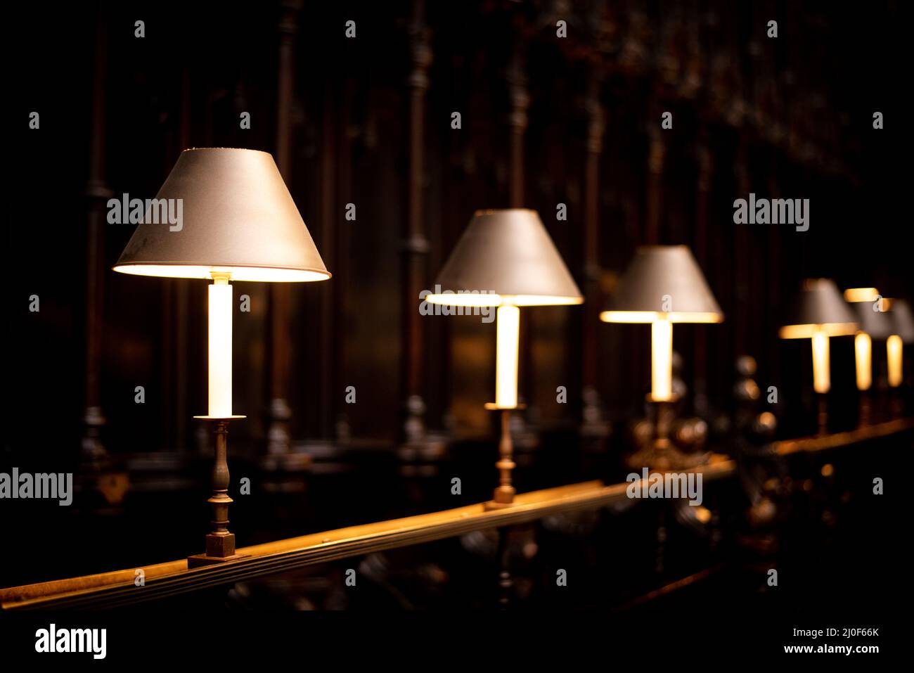 Row of decorative table lamps illuminating in a church Stock Photo - Alamy