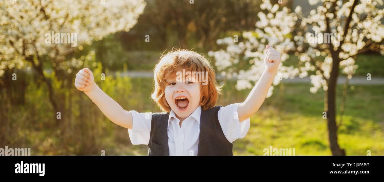 Happy child at school backyard. Blooming garden. Spring boy at park ...
