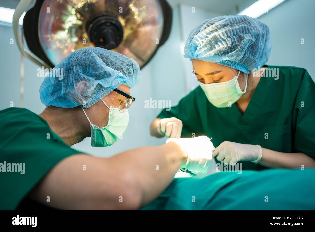 Asian Professional surgeons team performing surgery in the operating ...