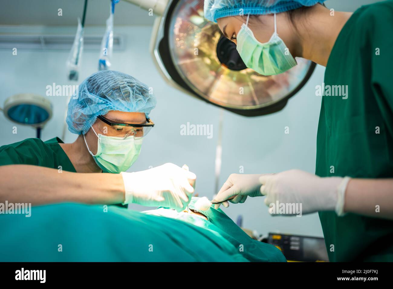 Asian Professional surgeons team performing surgery in the operating ...