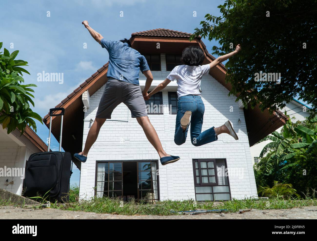 Happy couple in front of the New Home On Moving In Day, and start a new ...