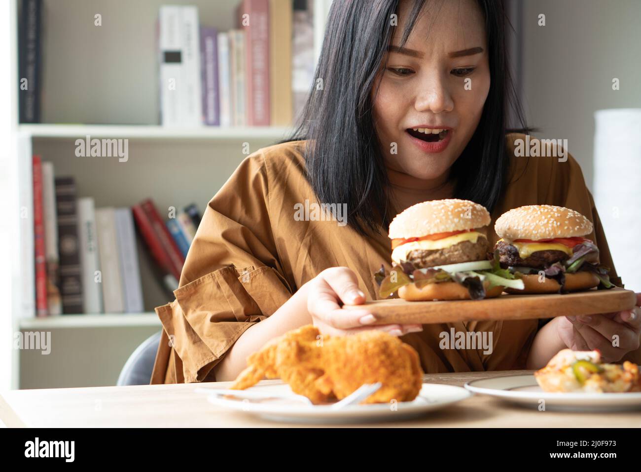 Obese woman eating fast food chicken hi-res stock photography and ...