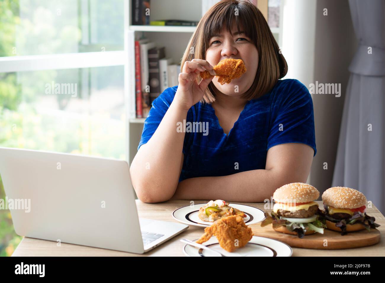 Obese woman eating fast food chicken hi-res stock photography and ...